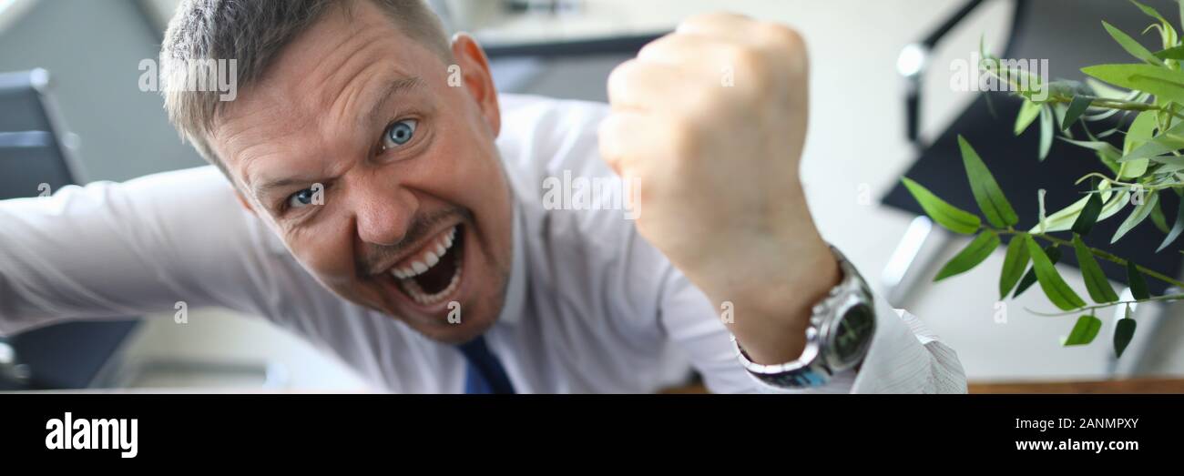Crazy boss screams threatens with a fist and looks Stock Photo - Alamy