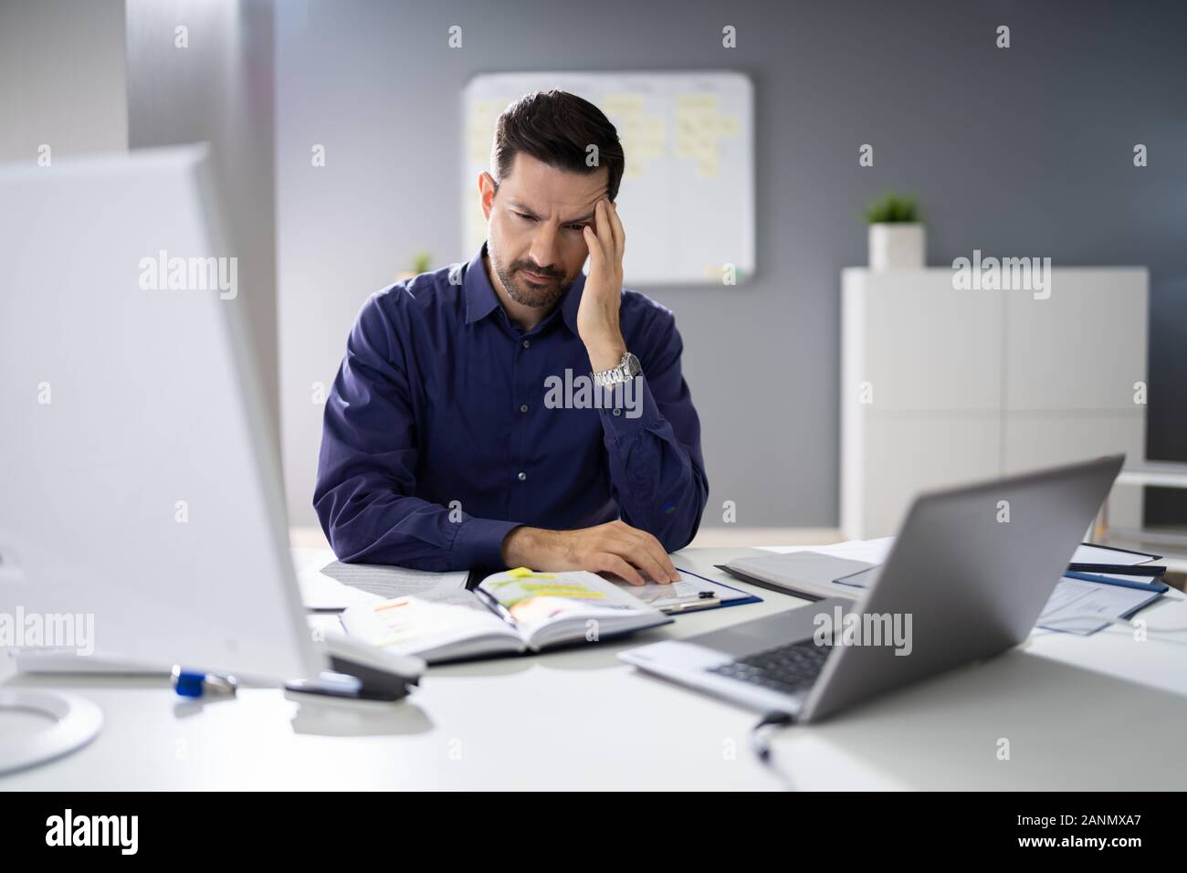 Man Suffering From Headache Working In Office Over Desk Stock Photo - Alamy