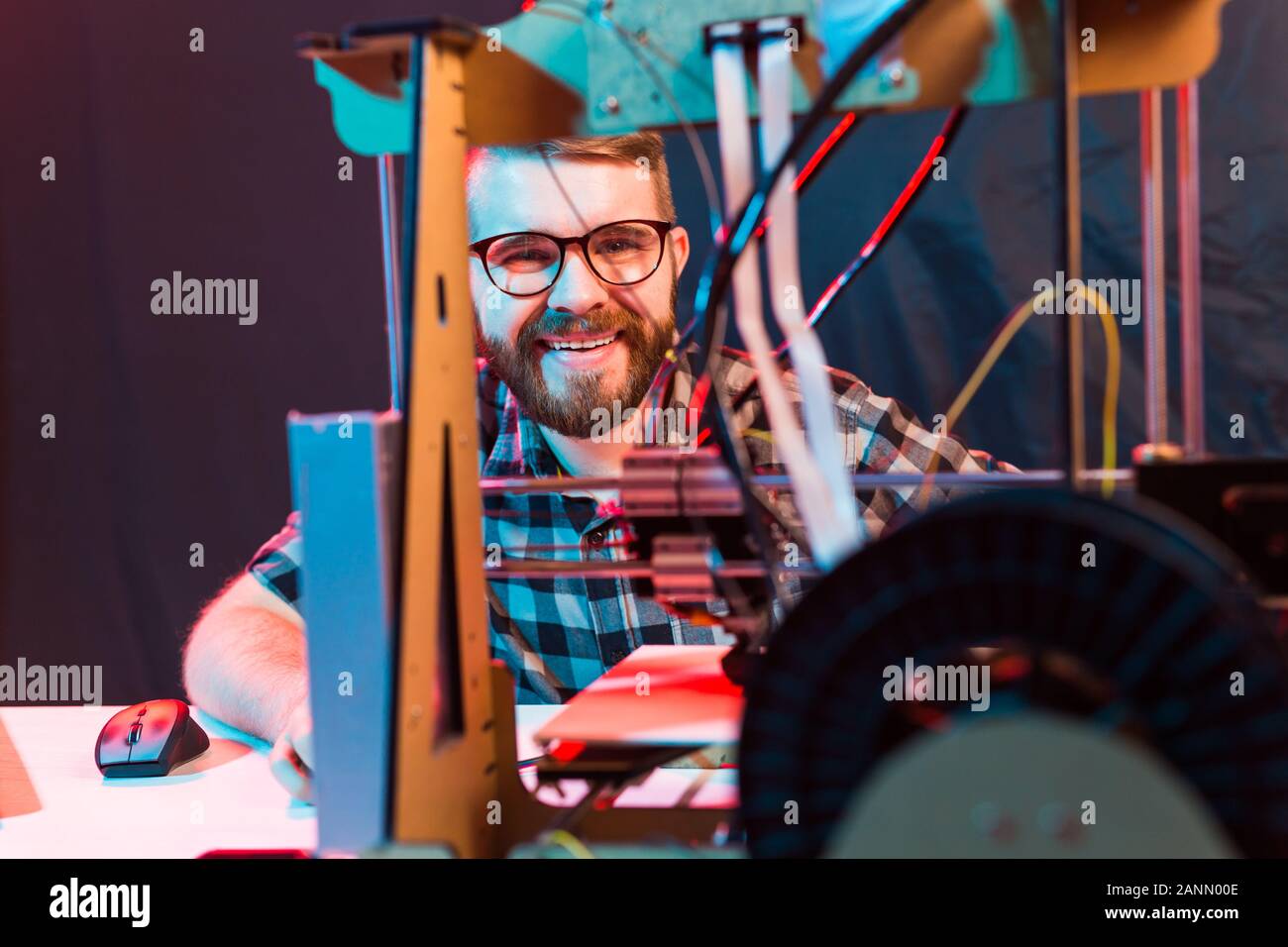 Young male designer engineer using a 3D printer in the laboratory and ...