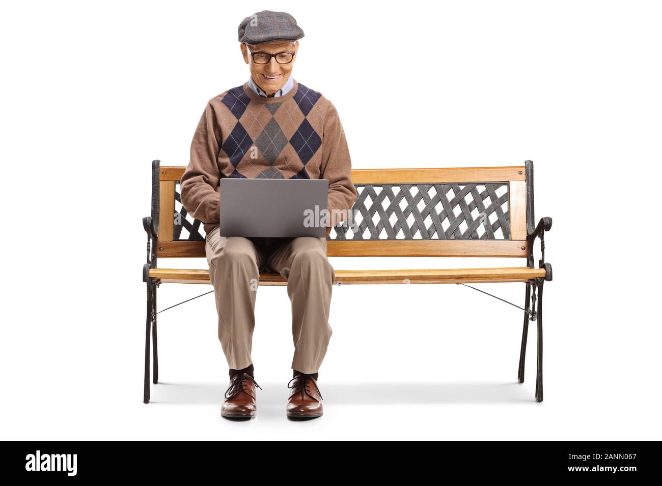 Senior man sitting on a bench and using a laptop computer isolated on ...