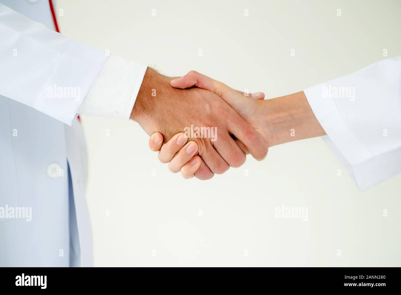 Doctor on white background giving handshake to another doctor showing ...