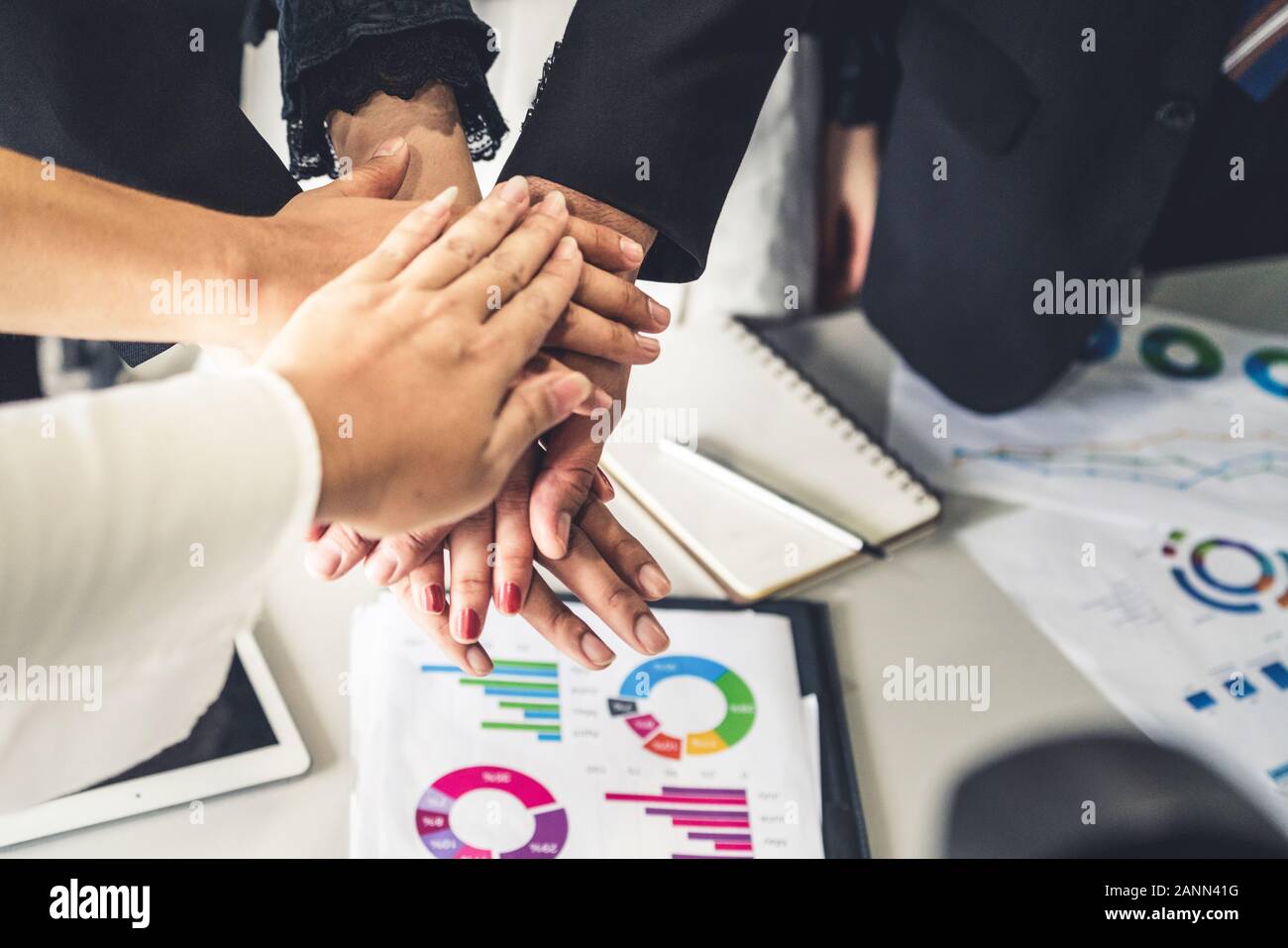 Many happy business people stacking hands together with joy and success ...
