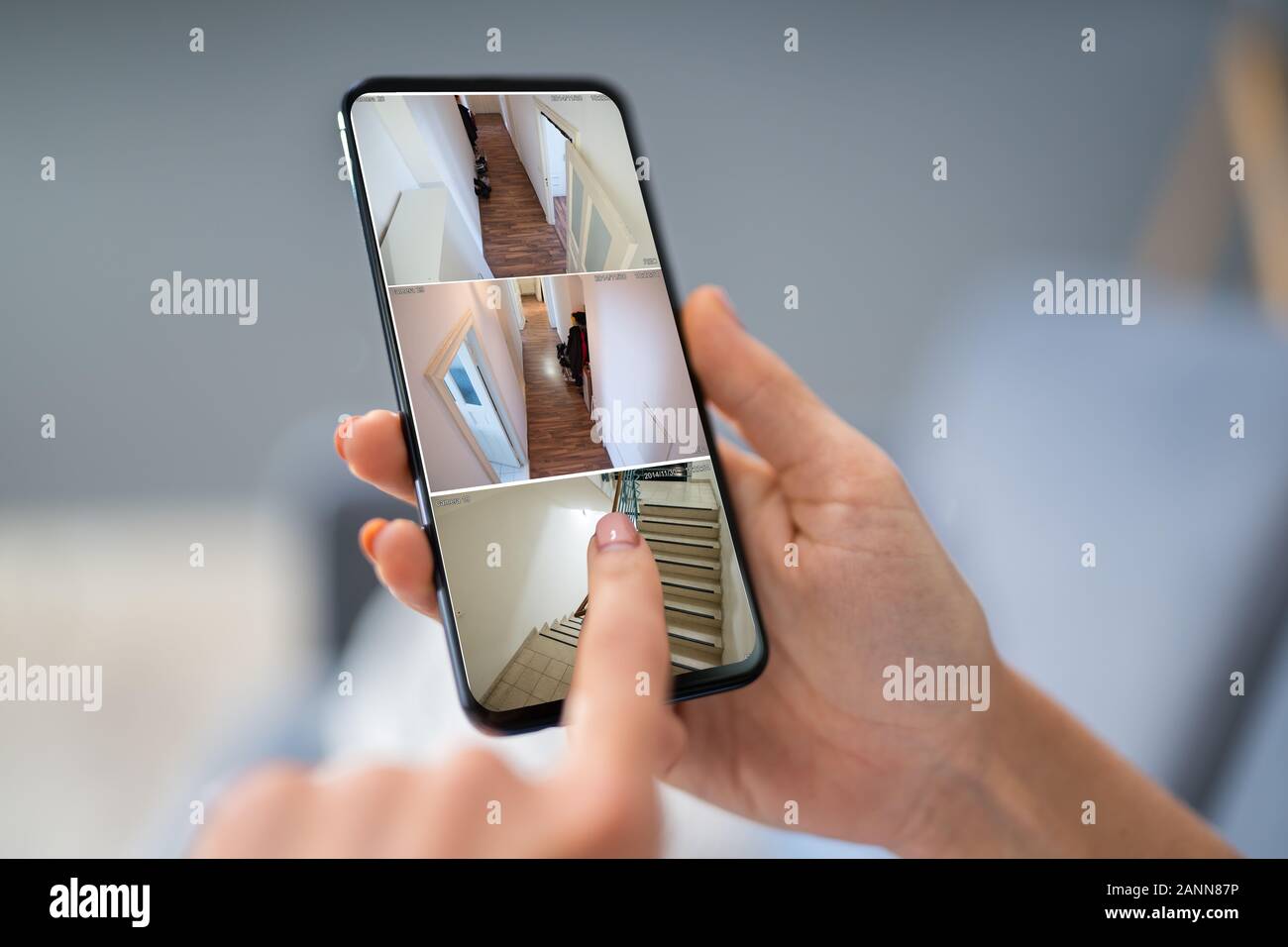 Close Up Of A Person's Hand Using Home Security System On Mobile Phone ...
