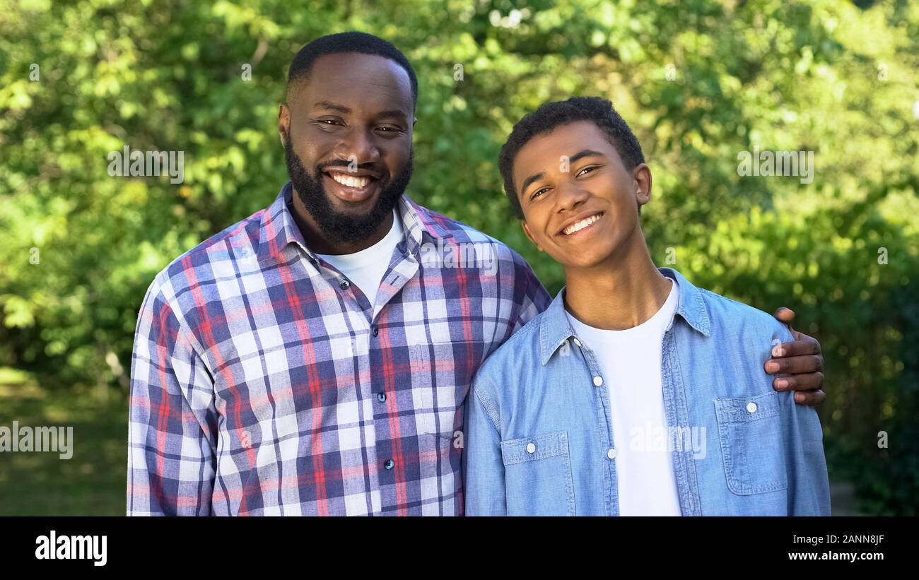 Cheerful black dad and son smiling on camera, trustful relations ...