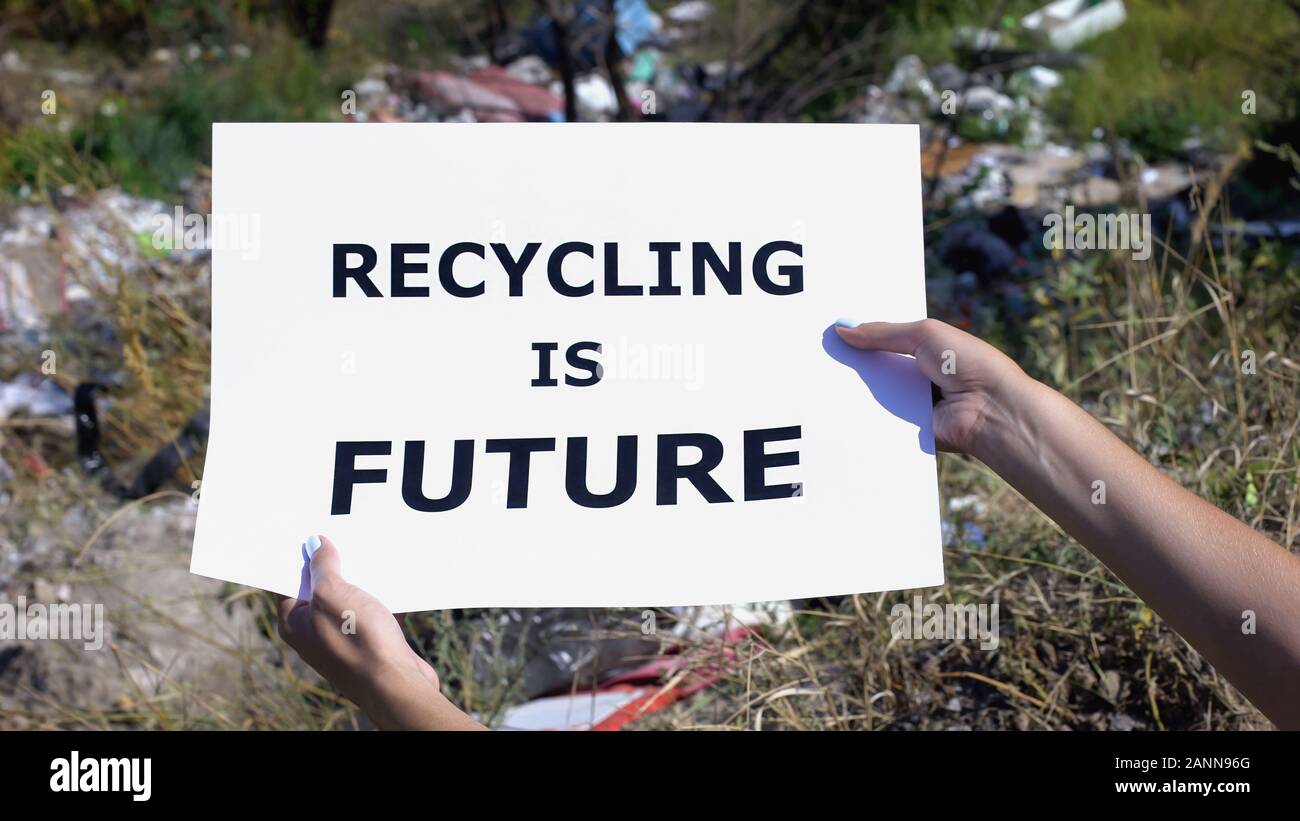 Recycling is future phrase on cardboard in hands against landfill ...