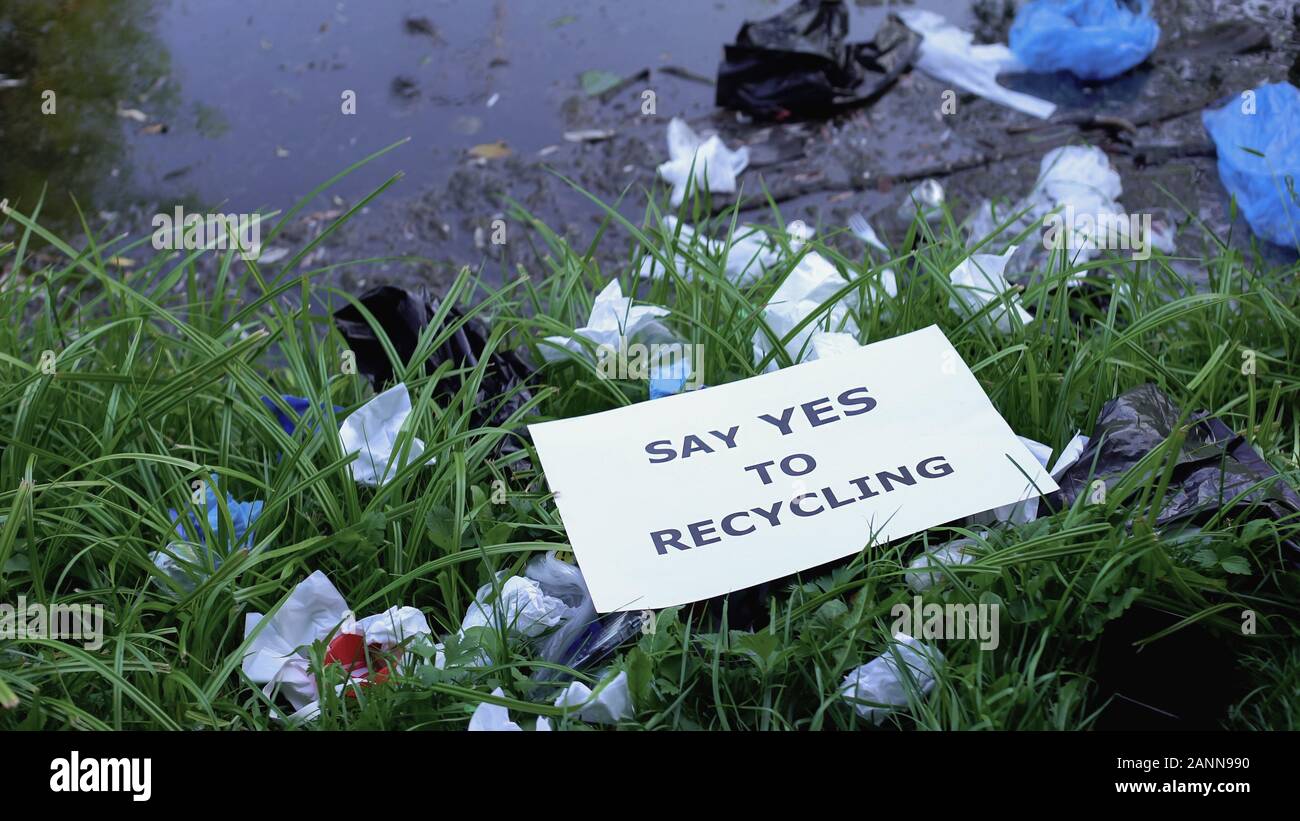 Cardboard with say yes to recycling phrase lying on open dumping among ...