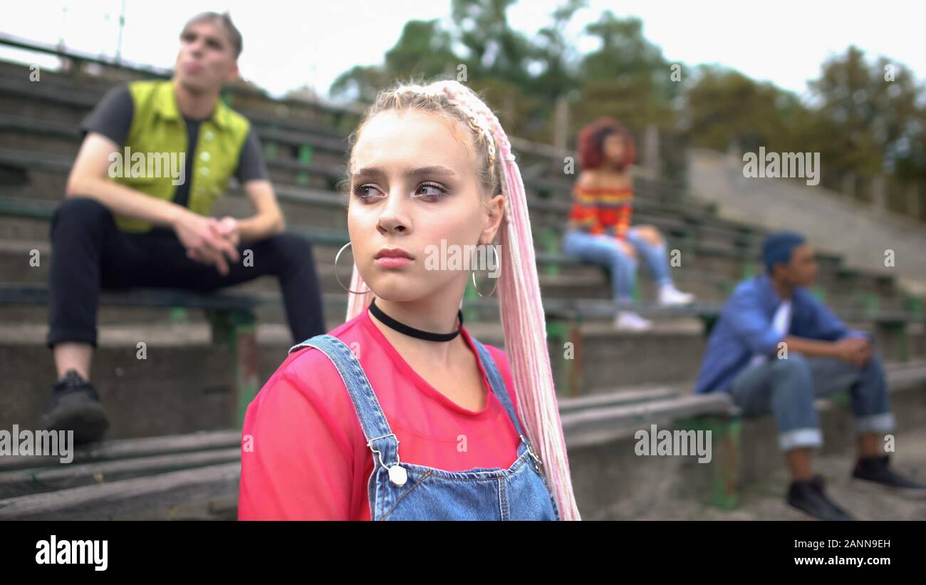 Stylish caucasian teenager sitting outdoors, awkward age problems ...