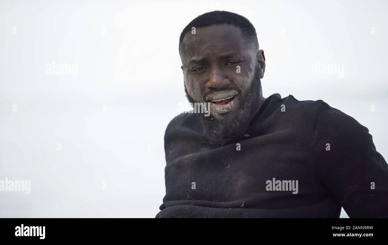 Male survivor after natural disaster crying, looking in camera ...
