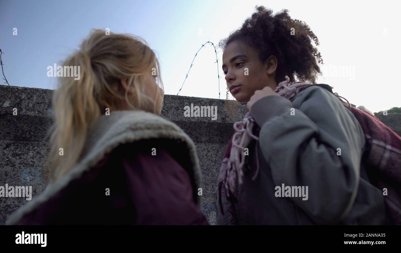 Teen refugee girls standing with bag, planning escape from warring ...