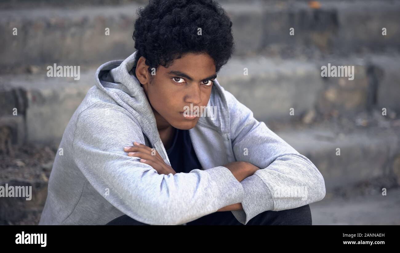 Lonely african male teen looking camera, economical crisis, puberty age ...