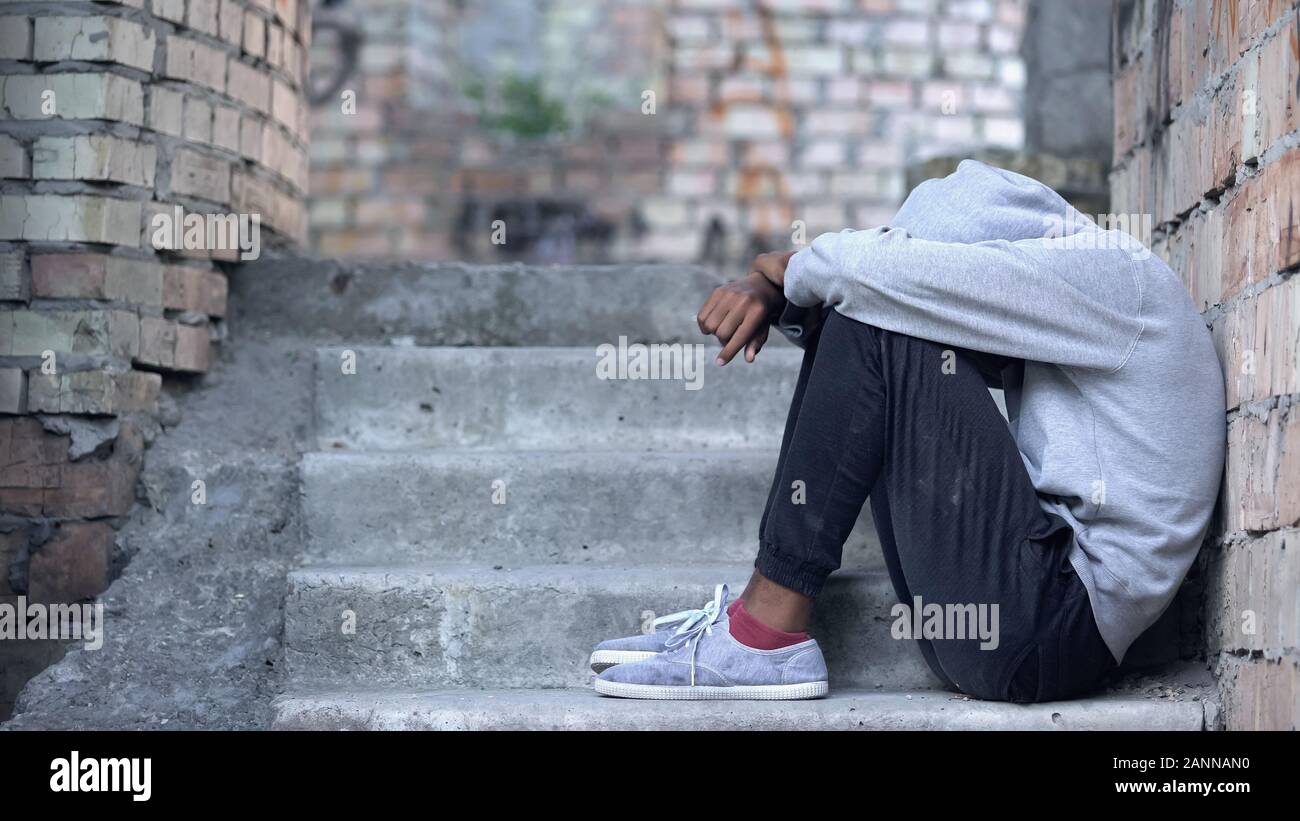 Lonely male teen sitting building stairs, misunderstanding depression ...
