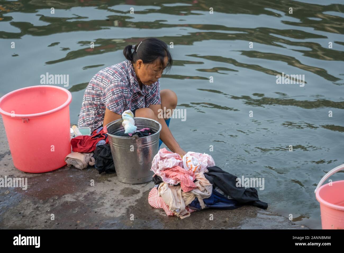 Feng Huang, China - August 2019 : Old woman doing laundry on the ...