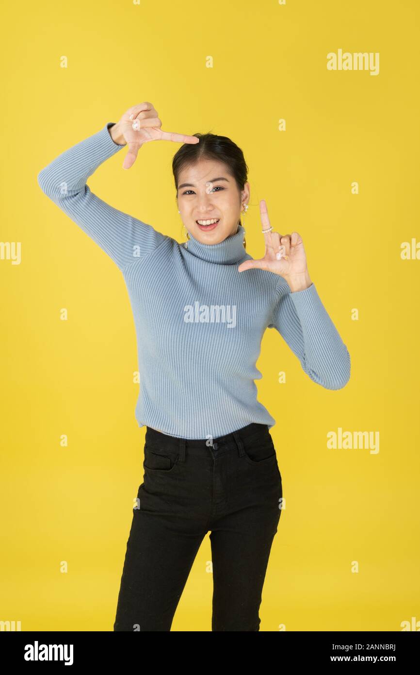 Women with thumbs pointing on both sides in the yellow background Stock ...