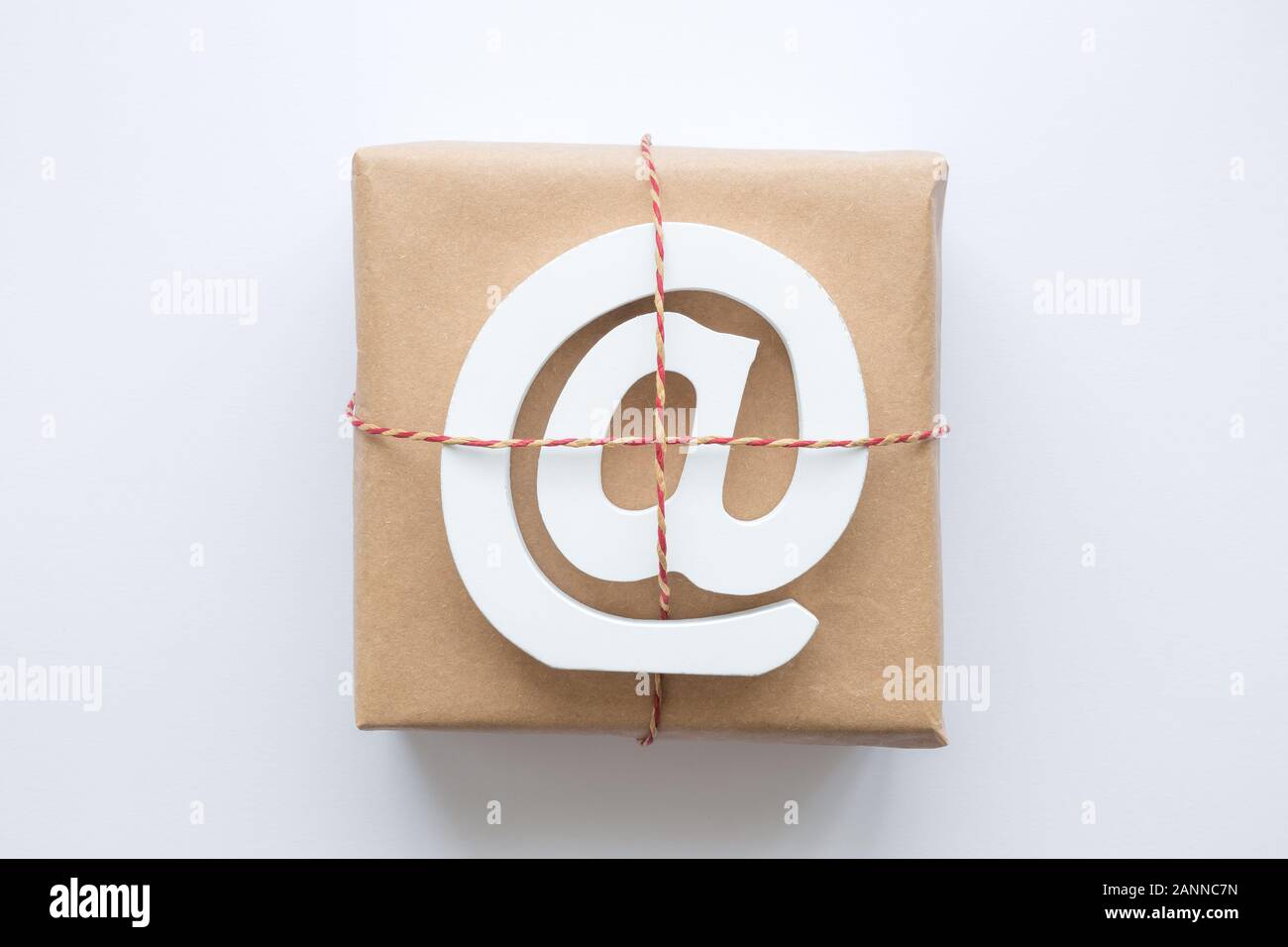 Flat lay of wrapped package with email symbol isolated on white ...