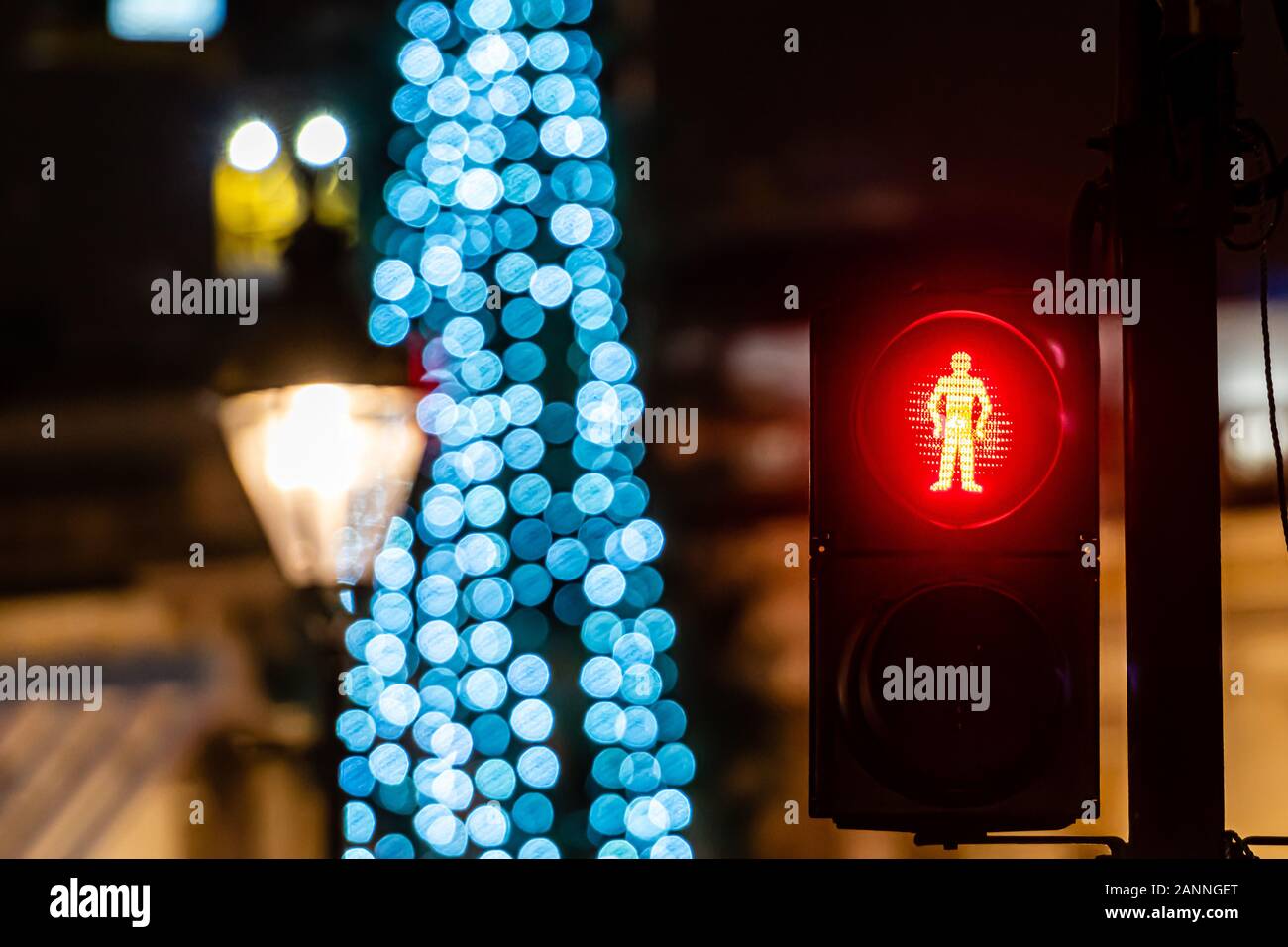 Pedestrian semaphore with green light and defocused Christmas tree ...