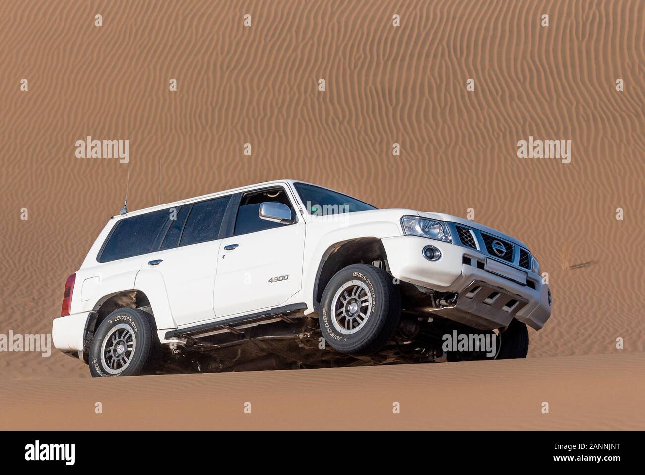 white nissan patrol super safari climbing sand dune splashing sands ...
