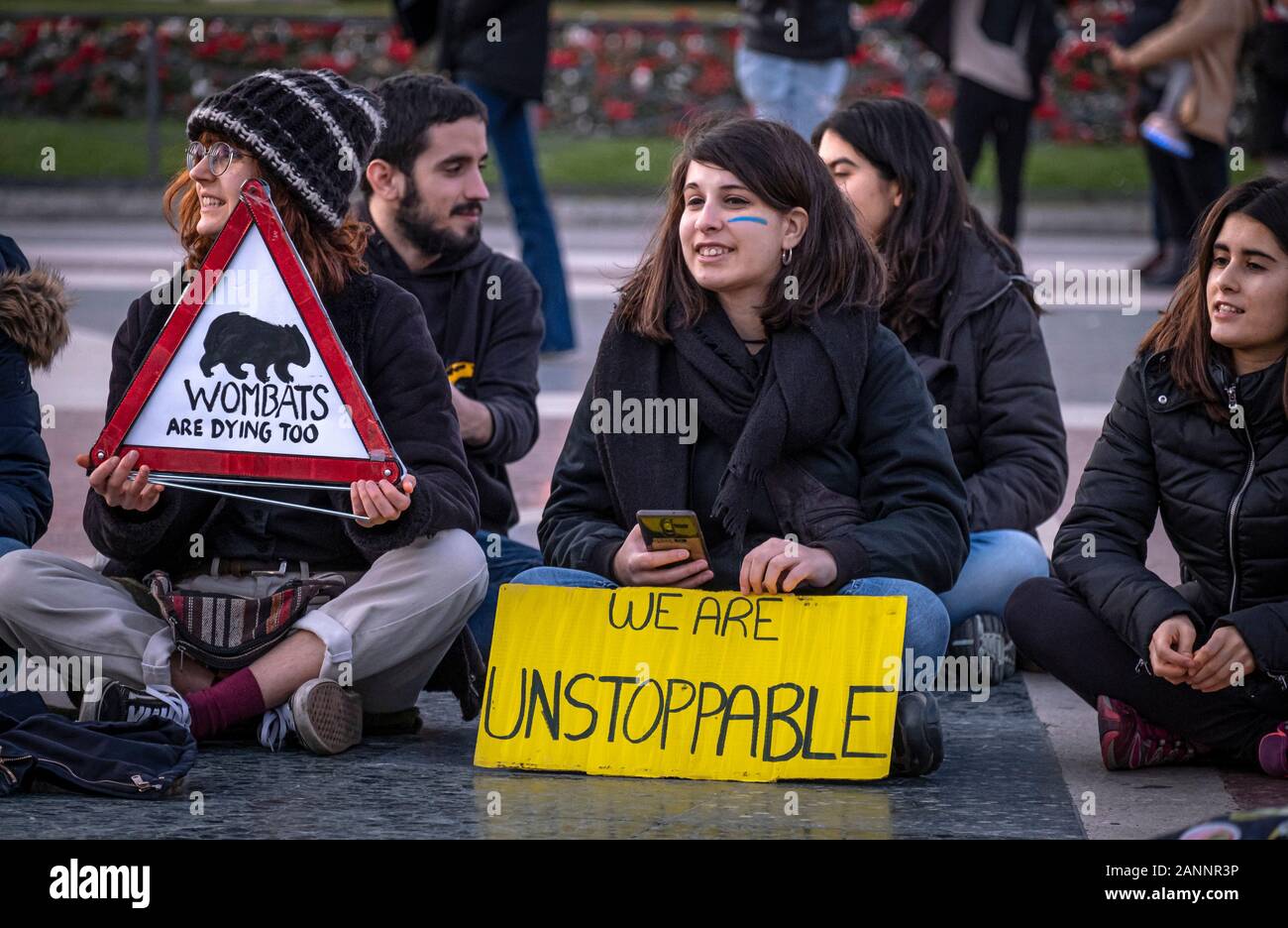 Climate activists hold placards while sitting on the ground during the ...