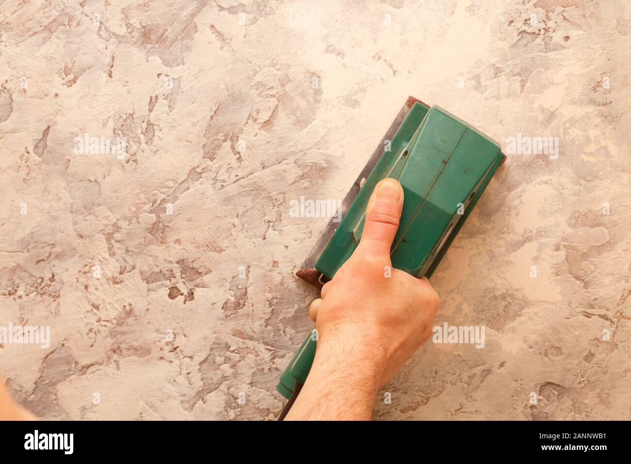 Electronic grinder in a hand. Grinding and leveling the surface of the ...