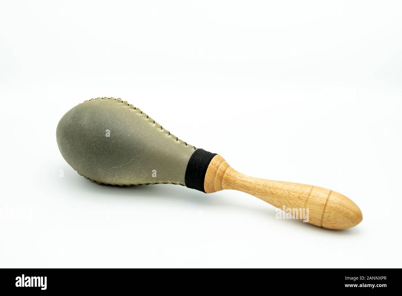 Closeup of a rawhide maracas lying on a white underground Stock Photo ...