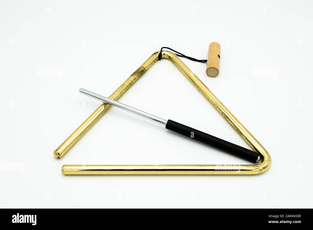 Closeup of a brass triangle lying on a white underground Stock Photo ...
