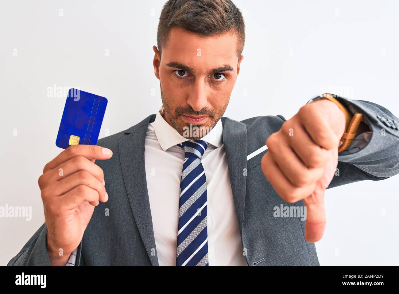 Young handsome business man holding credit card over isolated ...