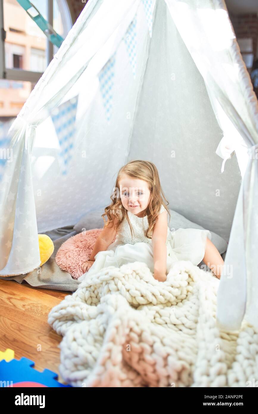 Adorable blonde toddler playing sitting on blanket inside tipi at ...