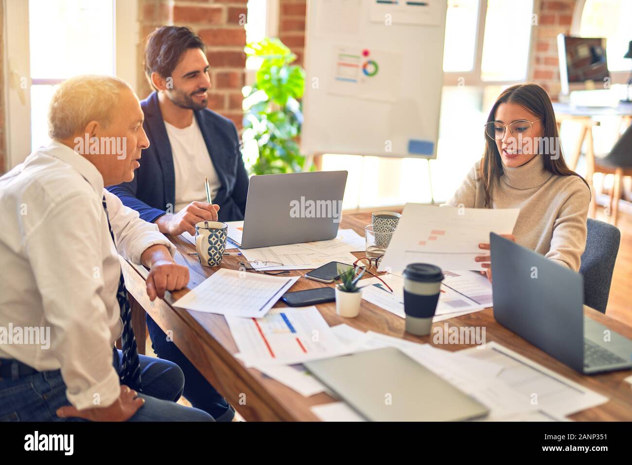 Group of business workers working together. Sitting on desk using ...