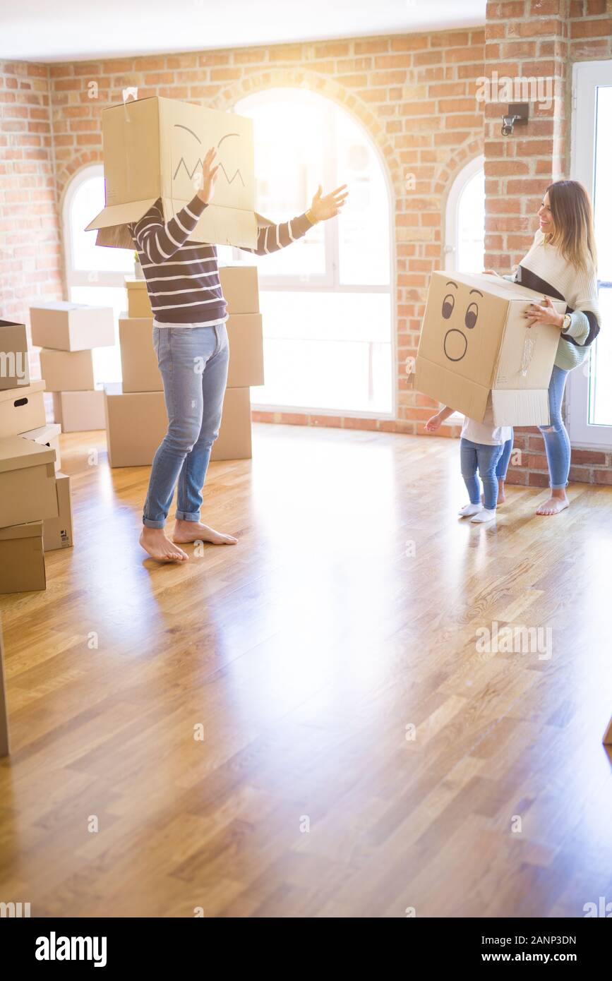 Beautiful famiily with kid playing with cardboard fanny boxes at new ...
