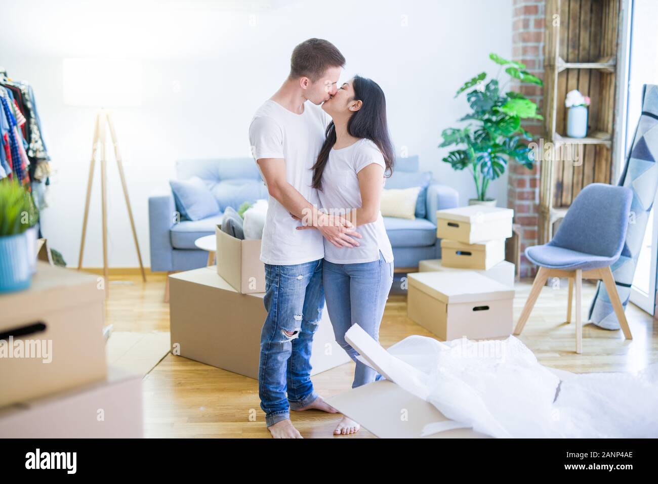 Young beautiful couple hugging at new home around cardboard boxes Stock ...