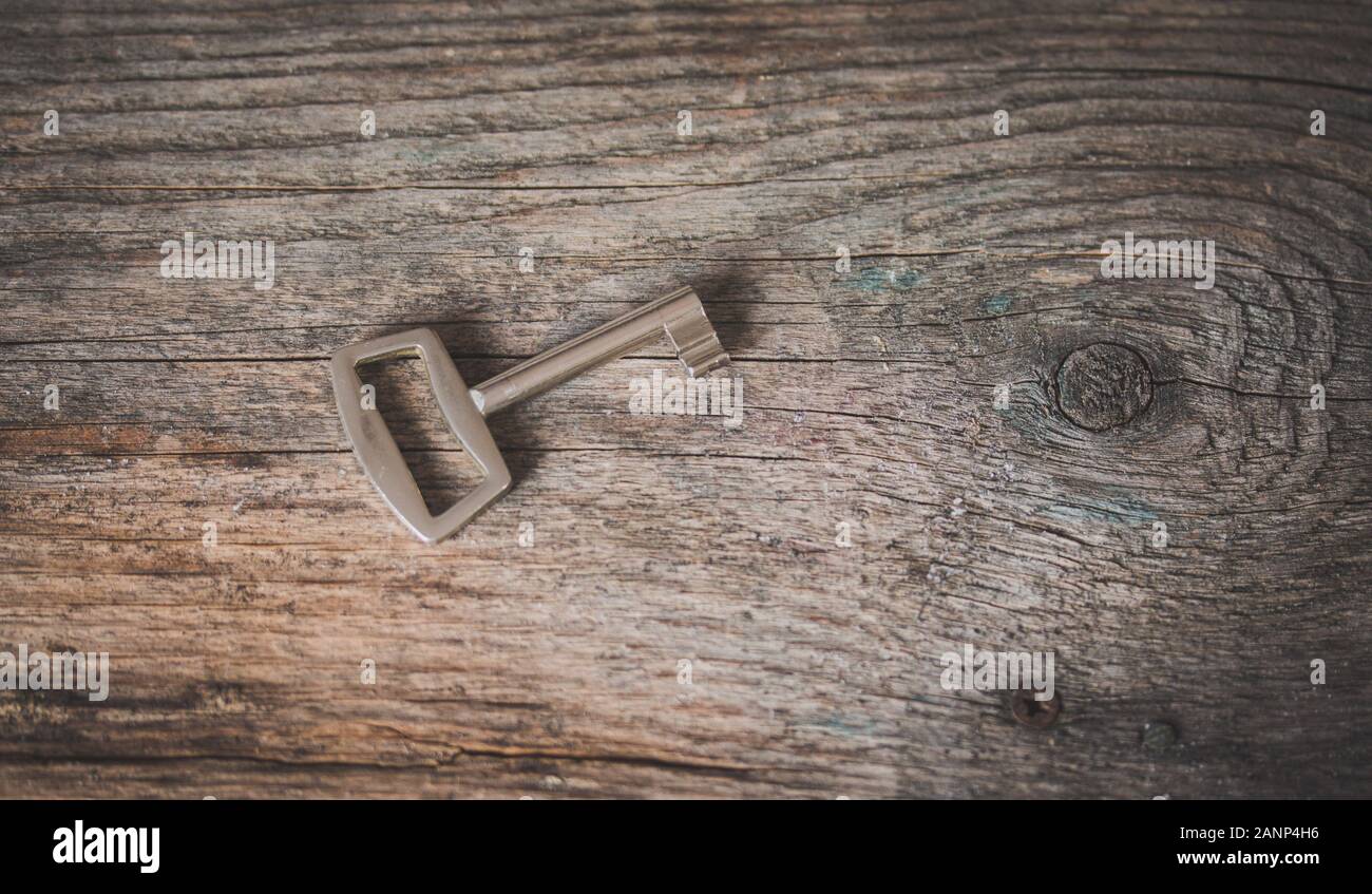 Old key is lying on a rustic wooden desk Stock Photo - Alamy