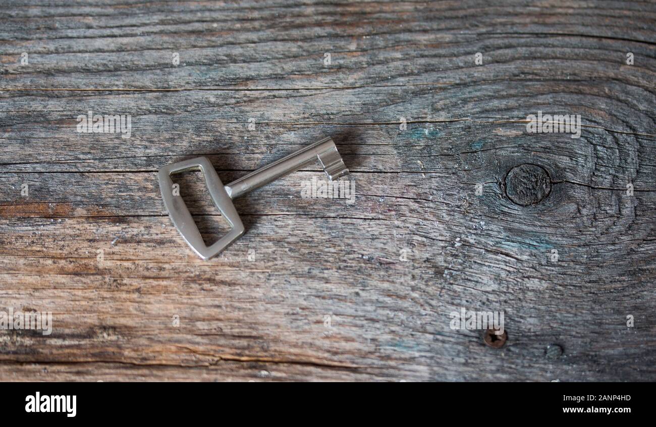 Old key is lying on a rustic wooden desk Stock Photo - Alamy