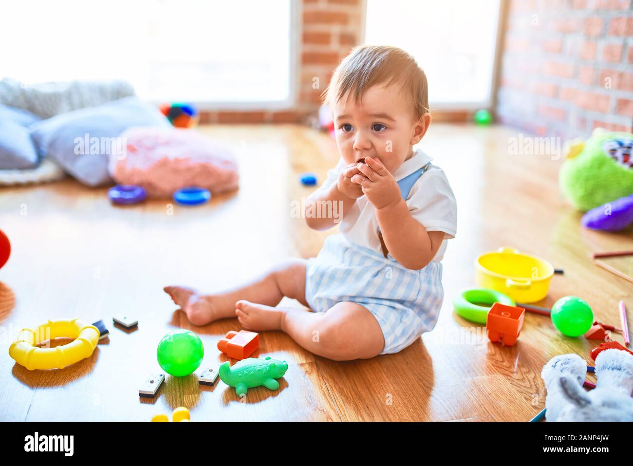 Adorable toddler playing around lots of toys at kindergarten Stock ...