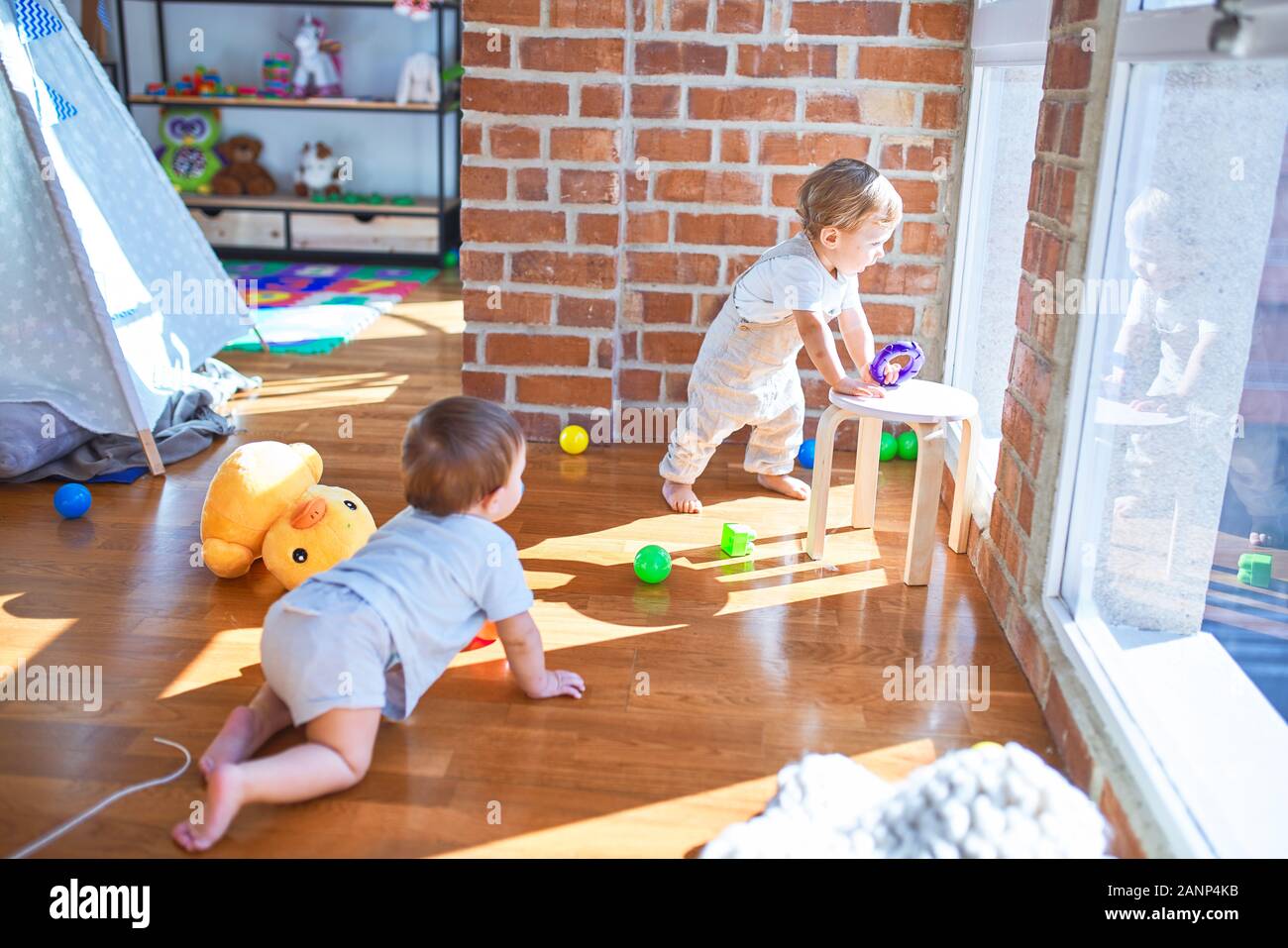 Beautiful toddlers playing around lots of toys at kindergarten Stock ...