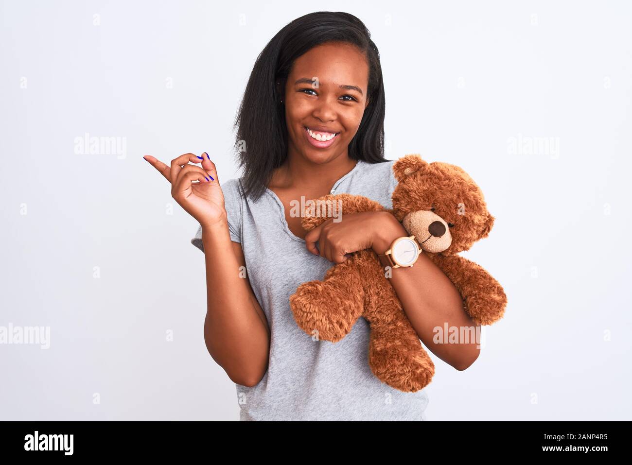 Young african american woman holding teddy bear over isolated ...