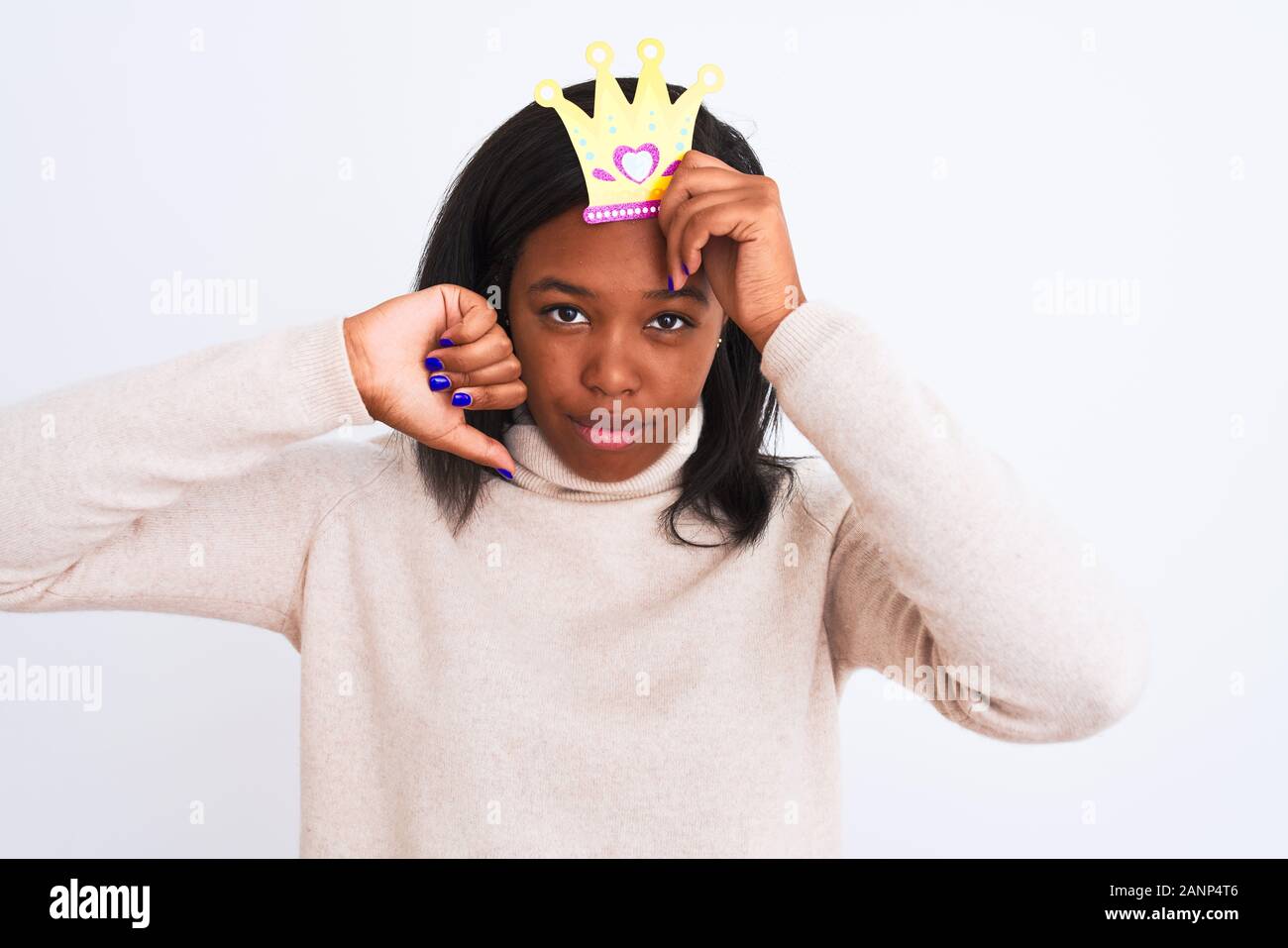 Young african american woman wearing pretend queen crown over isolated ...
