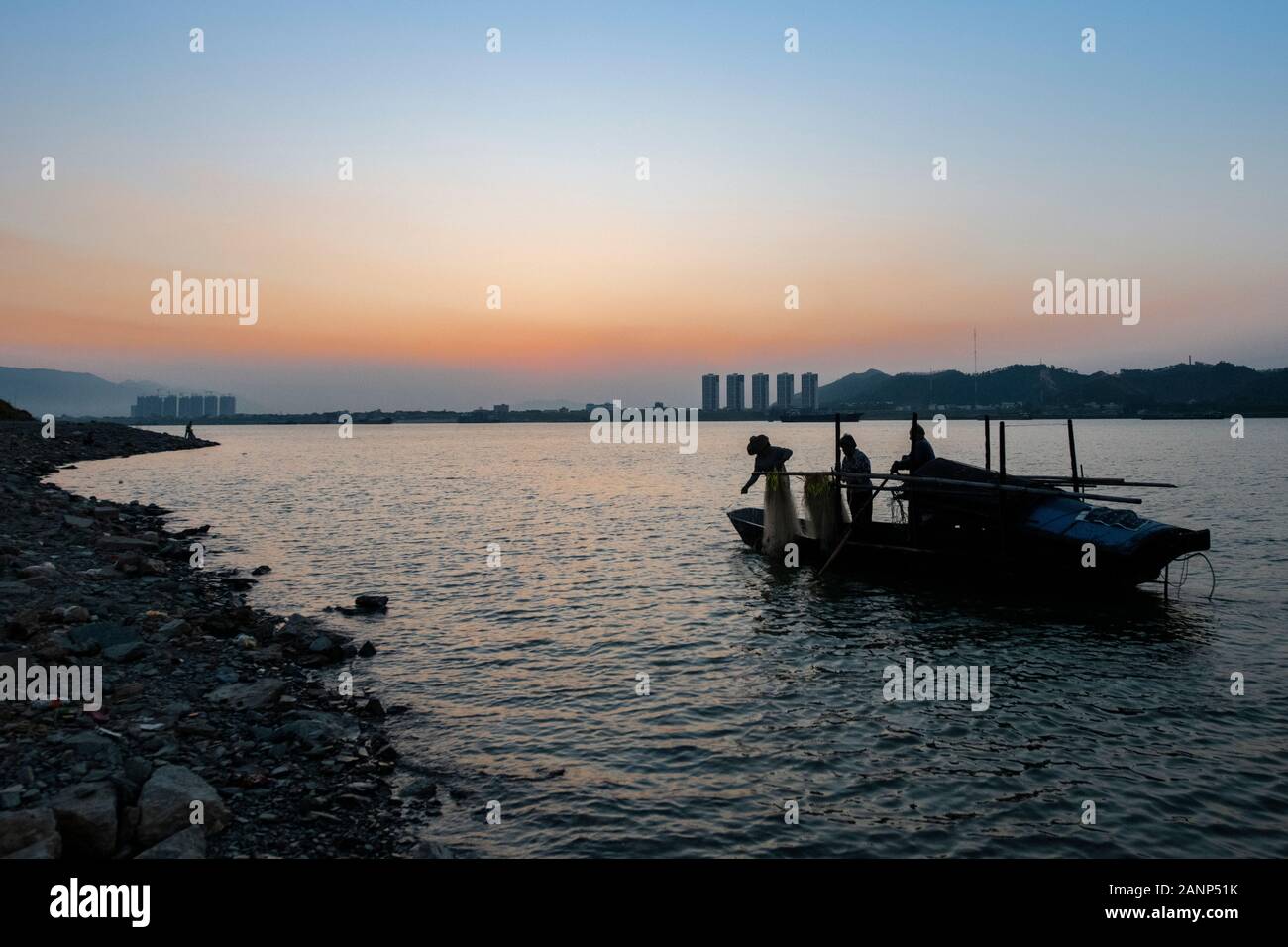 A family in a small fishing boat on the Xi River in Zhaoqing, China at ...