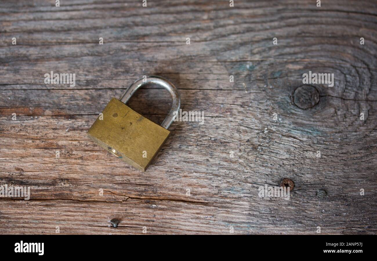 Padlock is lying on rustic wooden desk, close up Stock Photo - Alamy