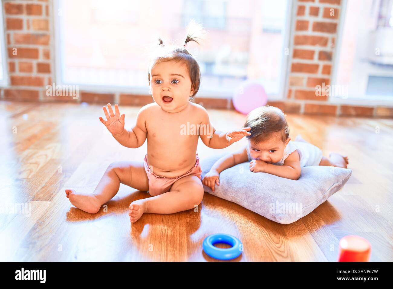Beautiful infant happy girls playing together at home kindergarten ...