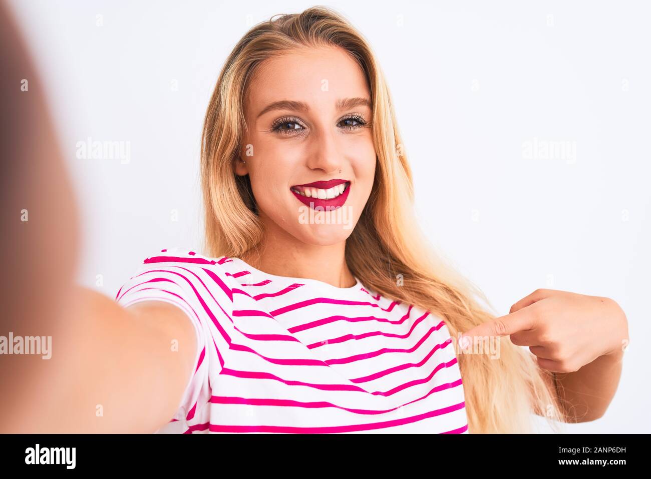 Beautiful woman wearing striped t-shirt make selfie by camera over ...