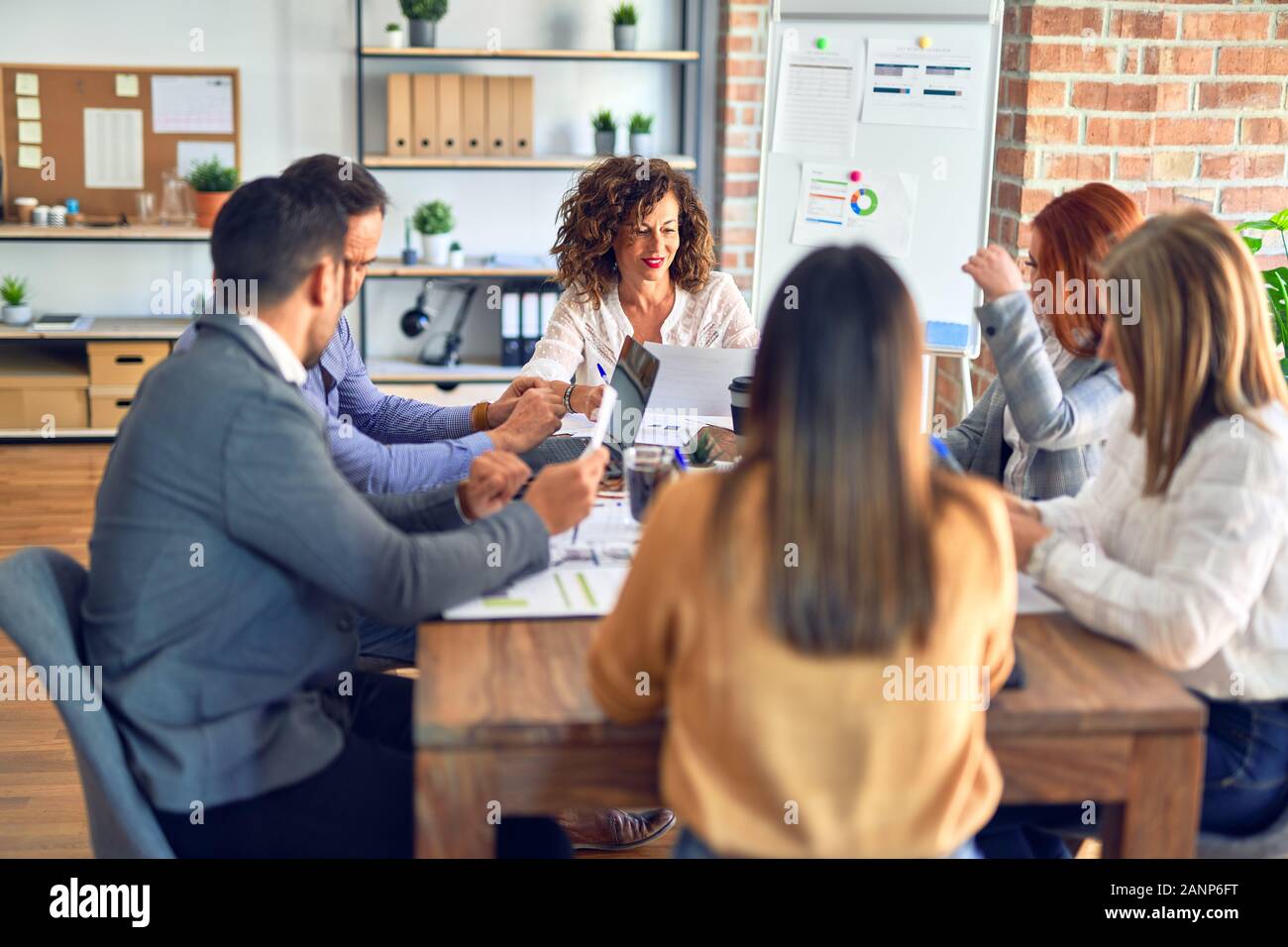 Group of business workers working together. Sitting on desk using ...