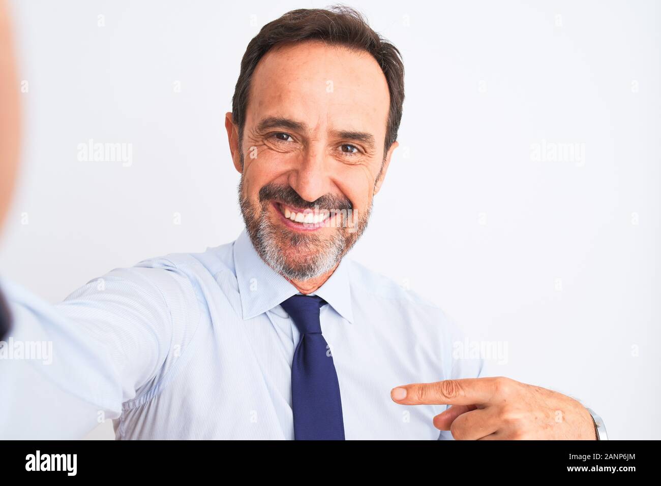 Middle age businessman wearing tie make selfie standing over isolated ...