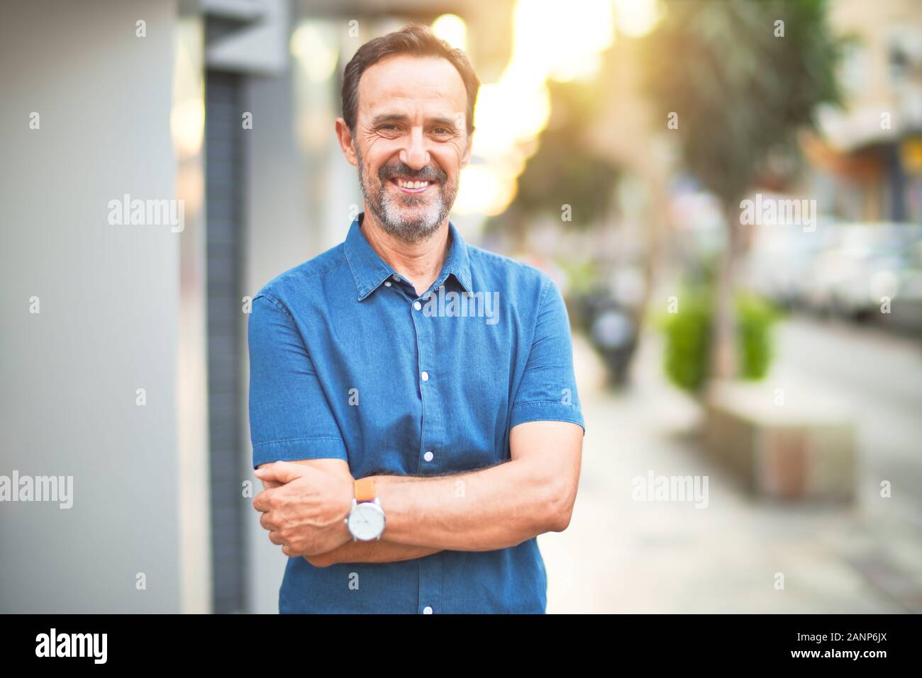 Middle age handsome man standing on the street smiling Stock Photo - Alamy