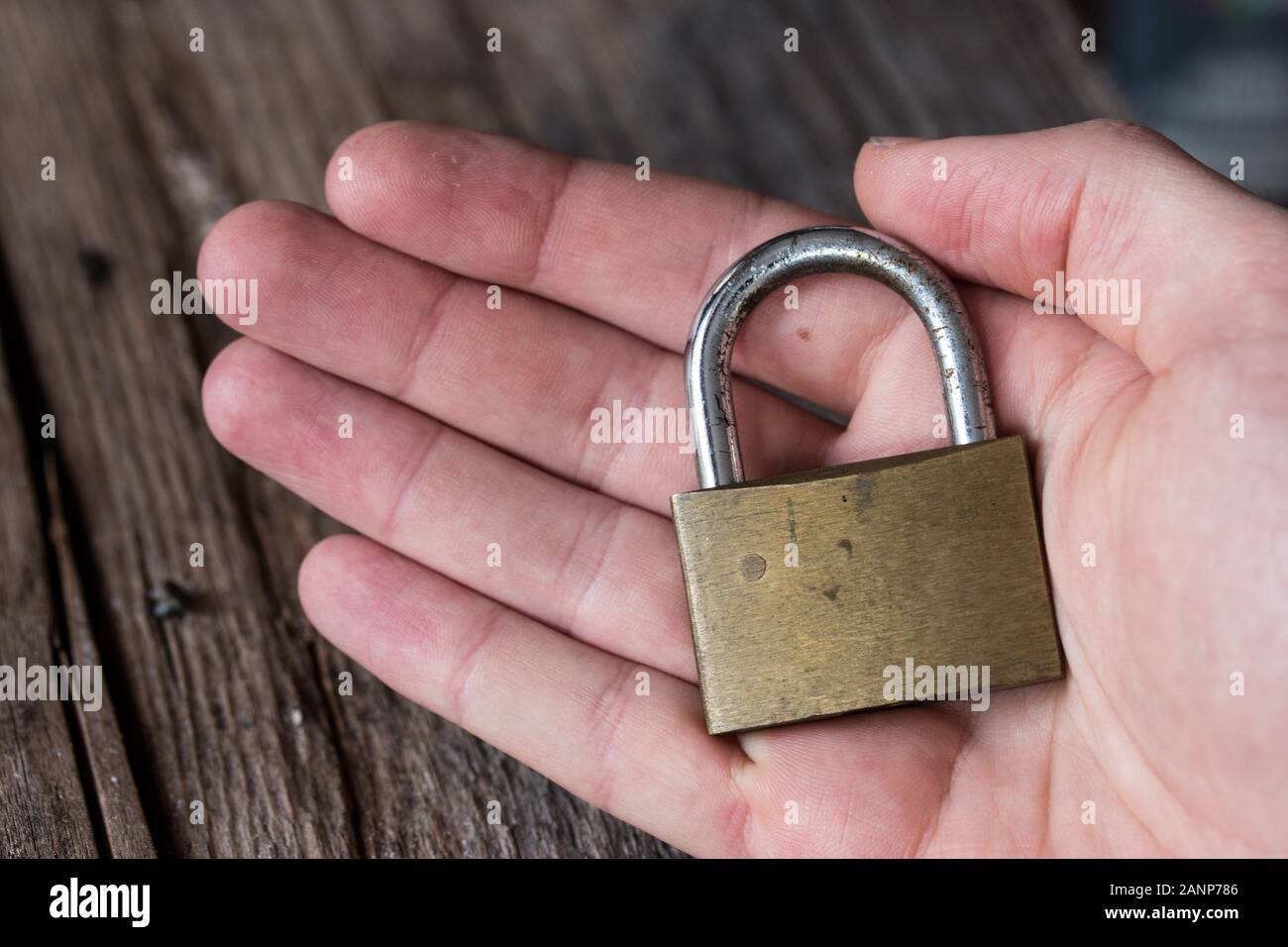 Padlock in the hand of a young man, close up Stock Photo - Alamy