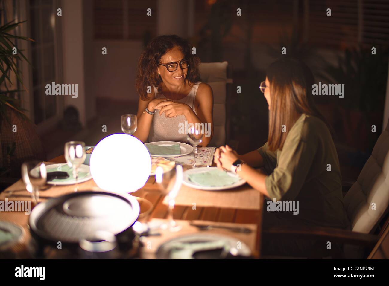 Beautiful mother and daughter on dinner smiling at terrace Stock Photo ...