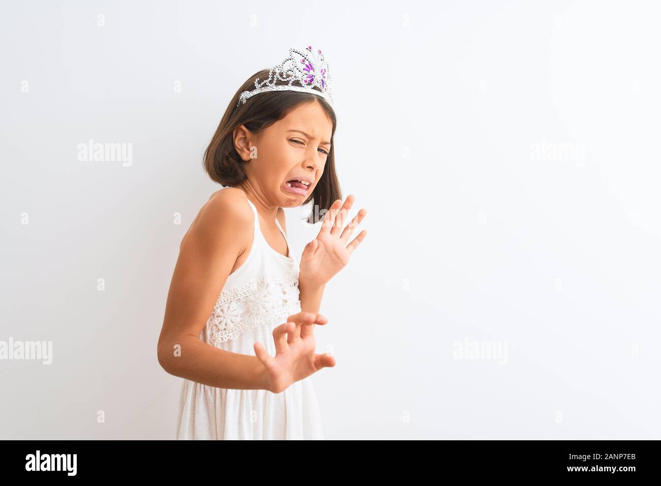 Beautiful child girl wearing princess crown standing over isolated ...