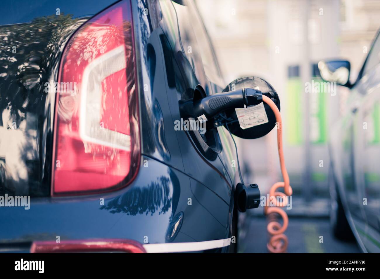 Electric car recharging with charge cable and plug leading to charge ... Electric car recharging with charge cable and plug leading to charge ...