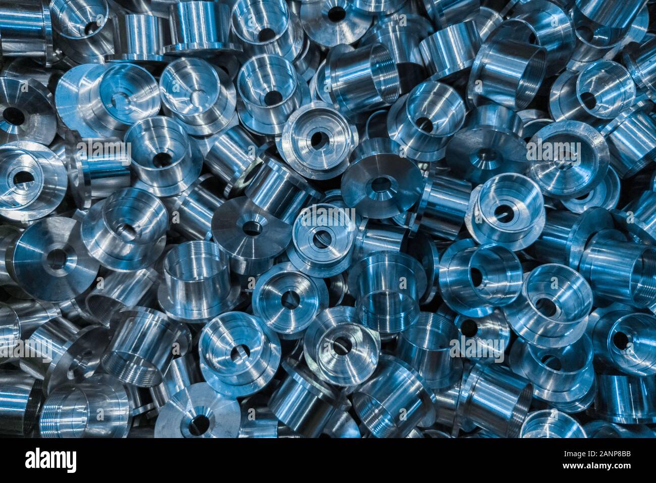 An industrial background with a pile of shiny metal cnc aerospace parts ...