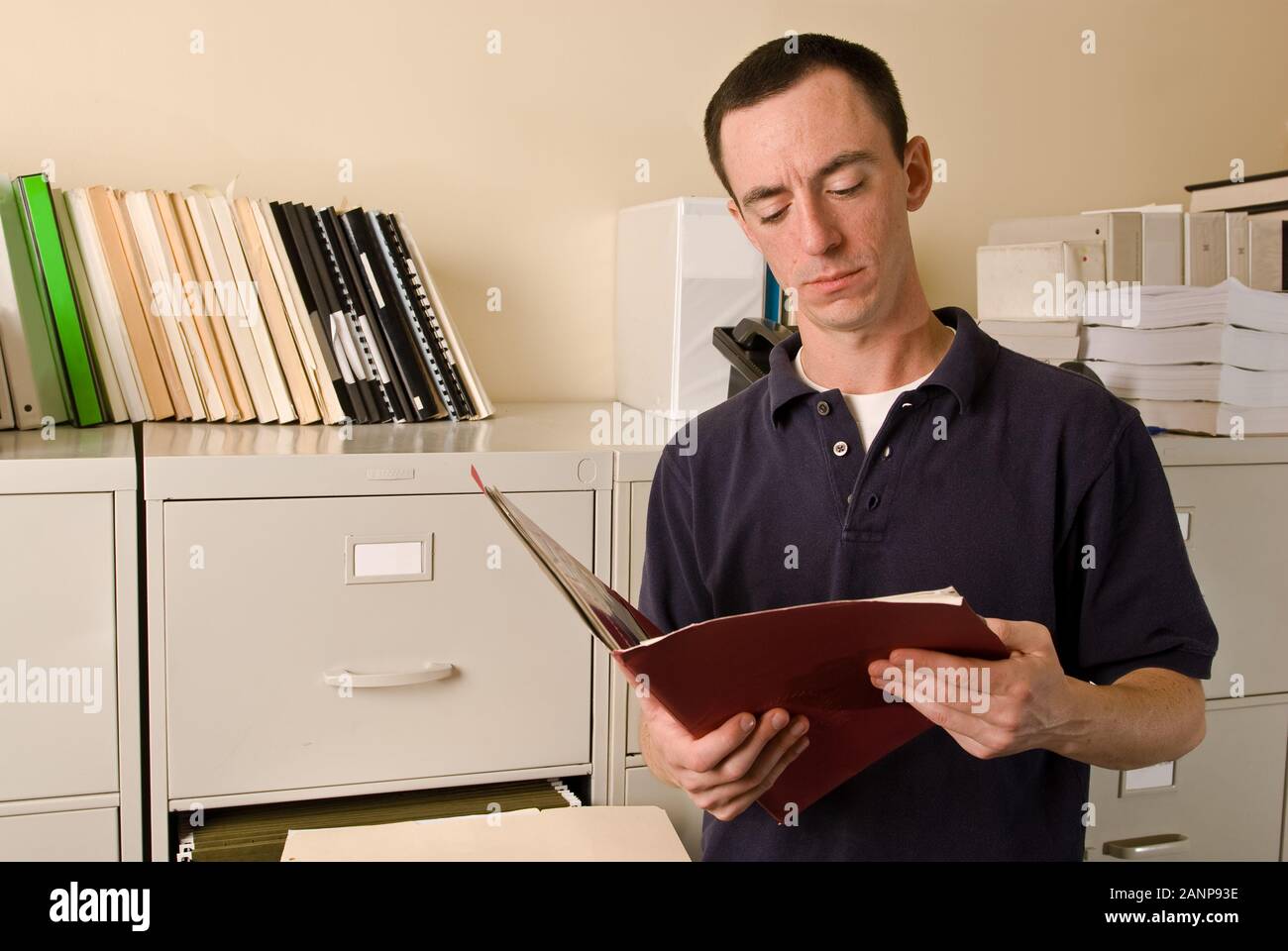Caucasian male reading a file in a filing room Stock Photo - Alamy