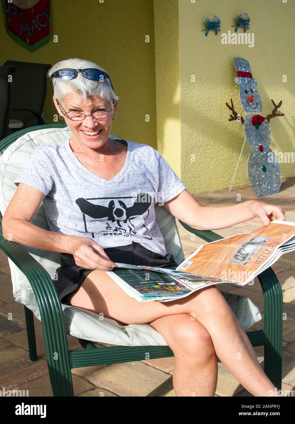 woman reading newspaper, outdoors, squinting, sunlight, 2 pair glasses ...