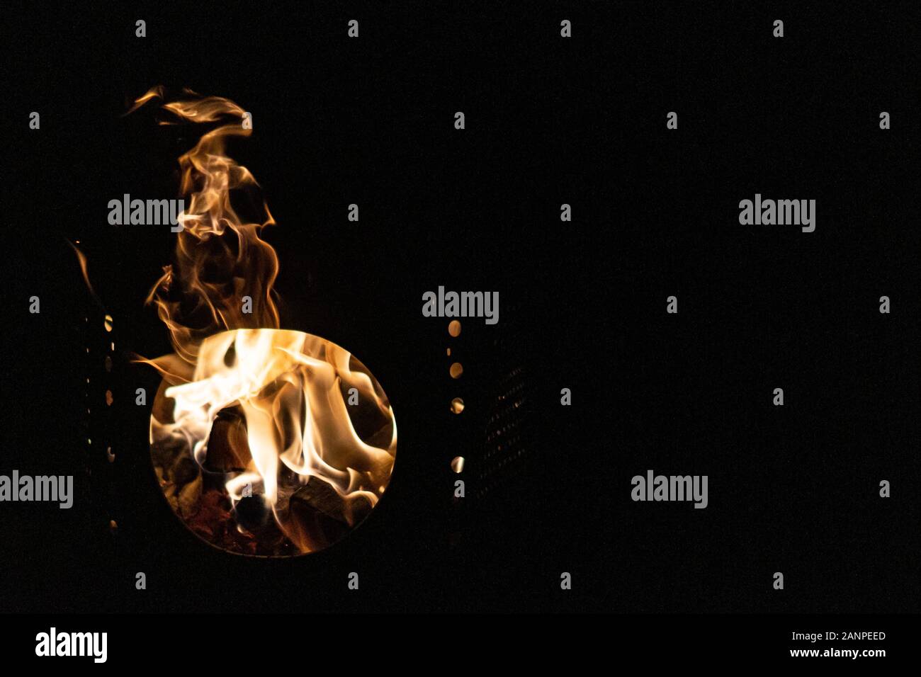 Bon fire in a barrel. Flames sticking out, burning wood Stock Photo - Alamy